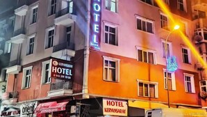 Um hotel de vários andares com um letreiro de neon chamativo indicando o nome.