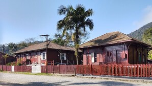 Um edifício de dois andares com telhado e cerca vermelhas.
