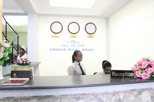 Bancada de recepção de hotel com relógios exibindo os horários de Washington, Etiópia e Londres.
