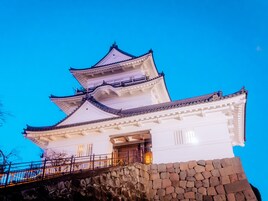 Um castelo japonês tradicional com vários níveis e base de pedra.