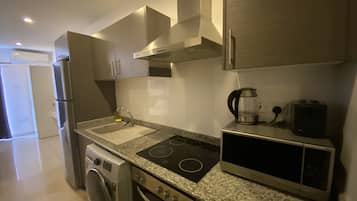 Apartamento executivo, vista para a cidade | Cozinha americana privada | Geladeira, micro-ondas, fogão, cooktop