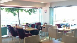 Restaurante com vista para a rua e carros estacionados.