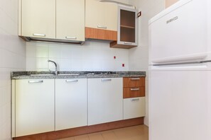 Apartamento, 1 quarto, sacada, vista parcial para o mar | Cozinha americana privada | Geladeira, cooktop, talheres/pratos/utensílios de cozinha