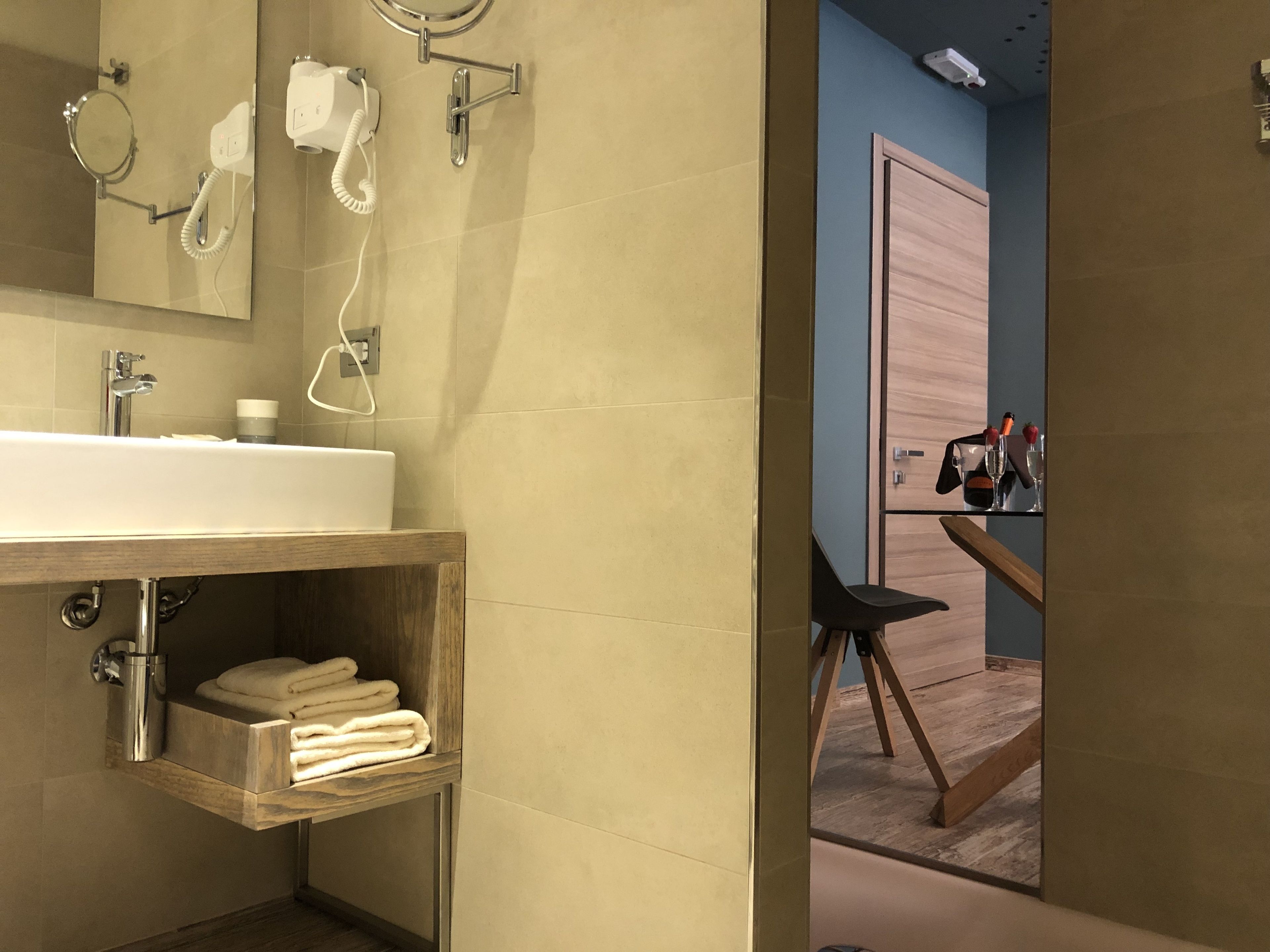 Uma casa de banho moderna com lavatório, porta-toalhas e espelho.