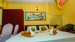 Quarto de hotel com cama, guarda-roupa, pintura e lustre.