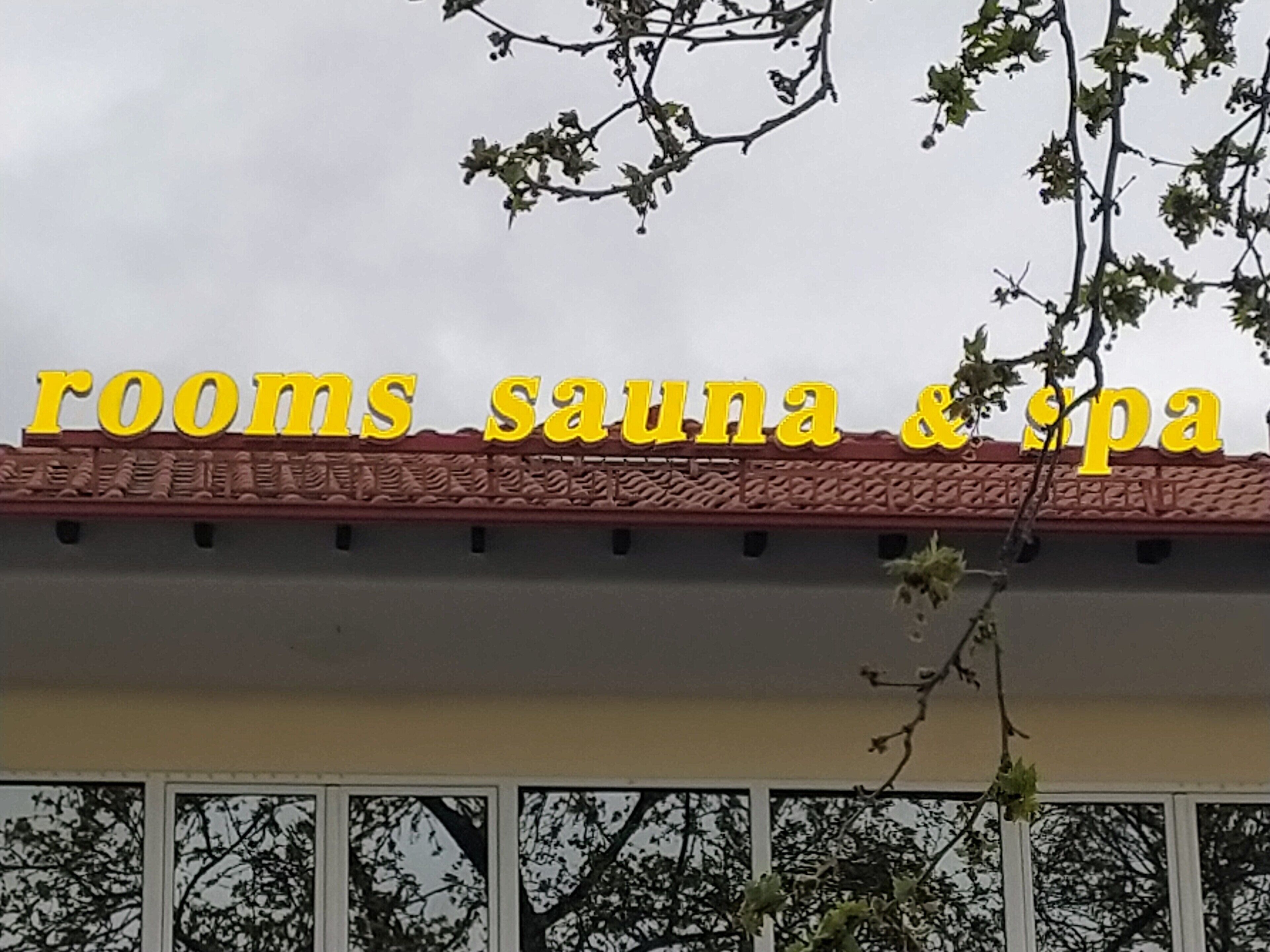 Um edifício com uma placa que diz "quartos, sauna e spa".