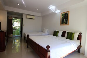 Quarto com uma cama grande, uma cama menor, uma cômoda e um quadro na parede.