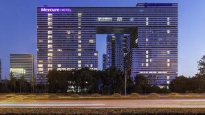 Um hotel moderno com design arquitetônico marcante, apresentando um amplo átrio central e vários andares.