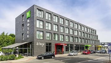 Um hotel moderno com fachada de tijolos, várias janelas e entrada coberta.