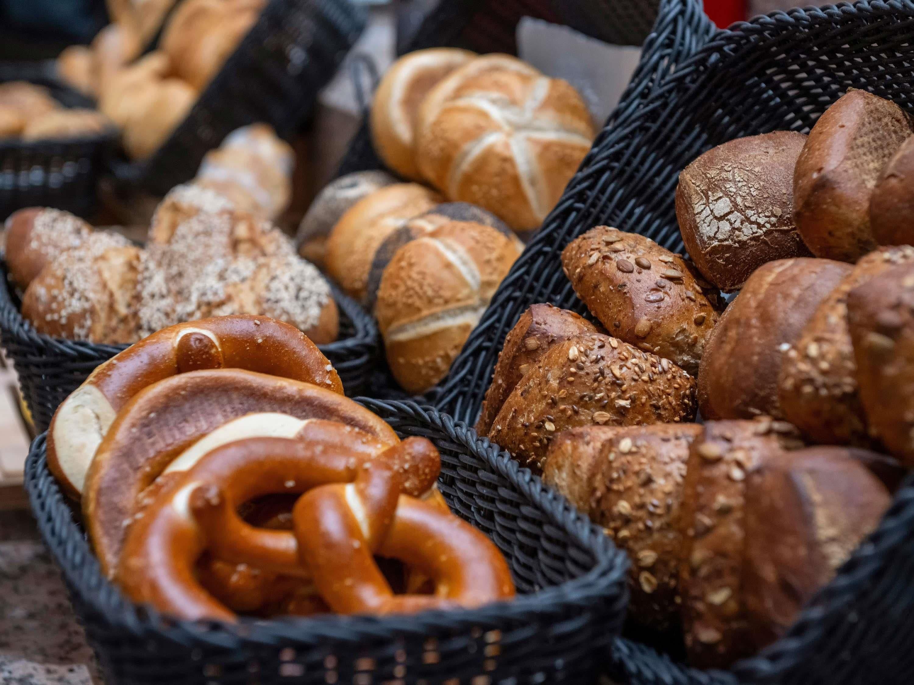 Diversos pães e pretzels em cestas.