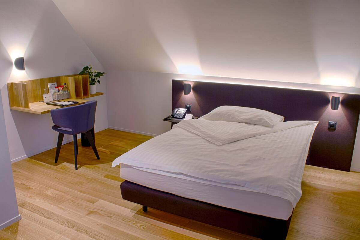 Quarto moderno com cama, escrivaninha e cadeira.