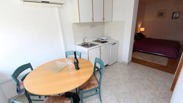 Uma cozinha compacta com área de refeições, uma cama e um pequeno espaço de estar.