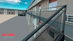 Hotel com design moderno, apresentando área externa coberta e um carro estacionado na frente.