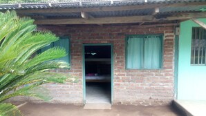 Uma casa de tijolos com varanda, porta e janela.