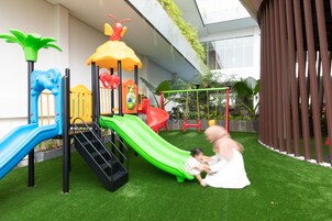 Uma área de recreação infantil com escorregadores e estruturas para escalar.
