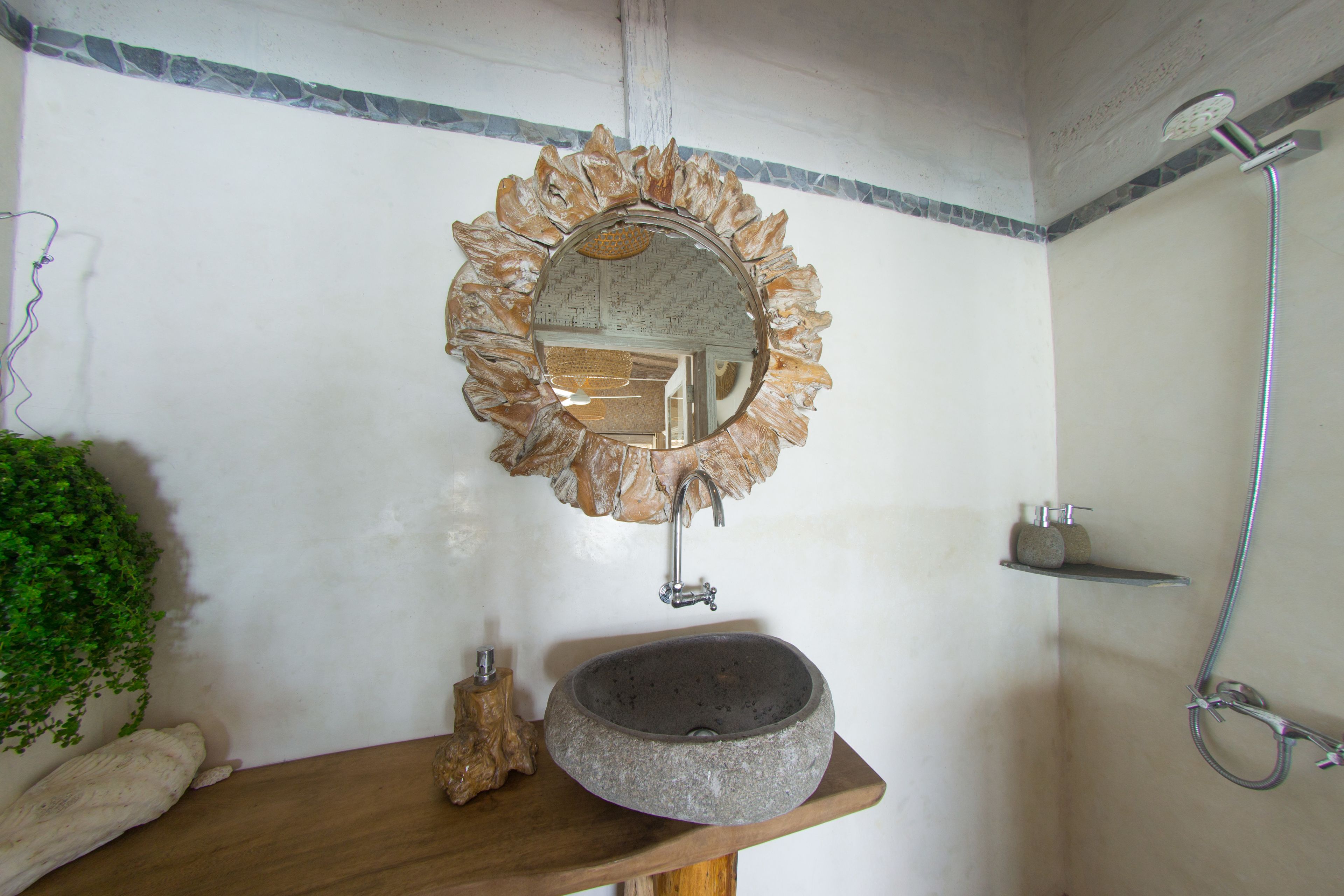 Uma casa de banho com lavatório de pedra, um espelho decorativo e uma cabine de duche.