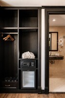 Um closet espaçoso com cabideiro, micro-ondas e um armário de armazenamento.