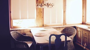 Uma sala de jantar com mesa, cadeiras e um candelabro.