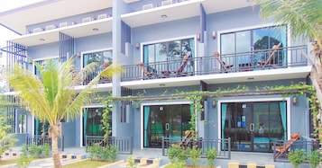 Hotel de vários andares com varandas, grandes janelas e áreas de estar ao ar livre.