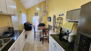 Uma cozinha com espaço de refeições, escada e sala de estar.