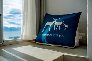 Um travesseiro com silhuetas de veado e cavalo e o texto "Together with you" em um peitoriz.