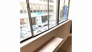 Um banco em um quarto com janela para a rua.