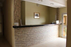 Uma área de recepção com parede de pedra e balcão preto.