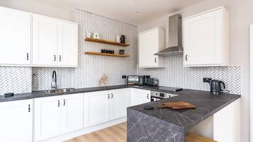 Apartamento Deluxe, 2 quartos | Cozinha privada | Um frigorífico, um micro-ondas, um forno, uma placa de cozinha