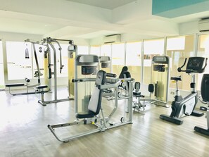 Uma academia com diversos equipamentos de exercícios, amplas janelas e um design moderno e impecável.