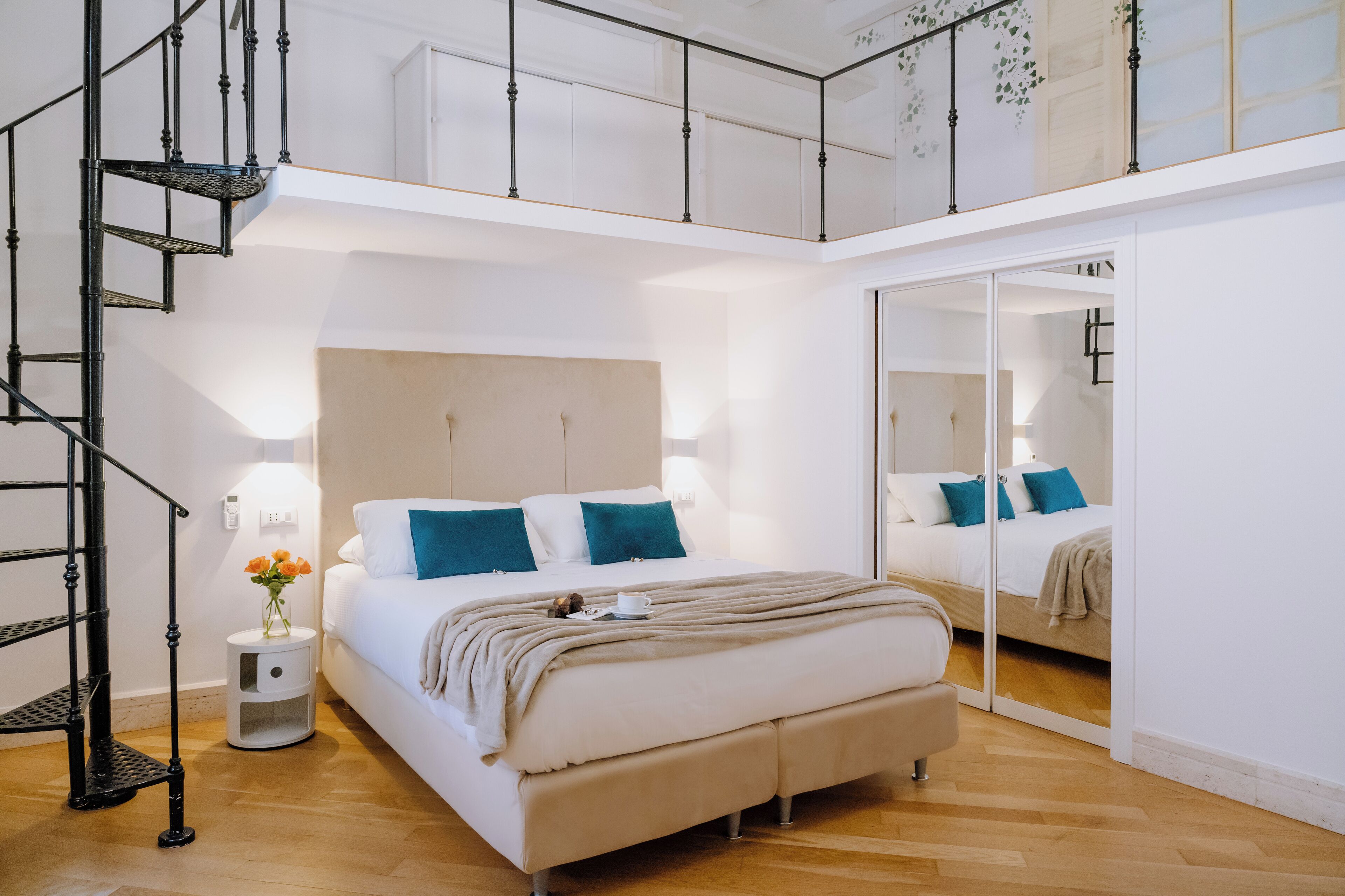 Quarto com cama, mesa de cabeceira e espelho.
