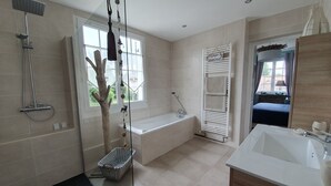 Uma casa de banho moderna com banheira, chuveiro e lavatório.