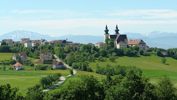 Uma cidade com uma igreja imponente e uma cadeia de montanhas ao fundo.