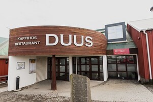 Um edifício com uma placa indicando 'DUUS' e 'Kaffihus Restaurant'.