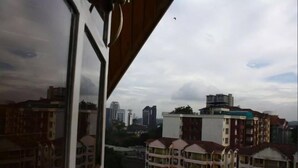 Vista de edifícios residenciais com vários andares e varandas, vista através de uma janela com moldura de madeira.