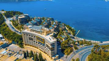 Hotel à beira-mar com construção curvilínea, estacionamento e vista para o mar.