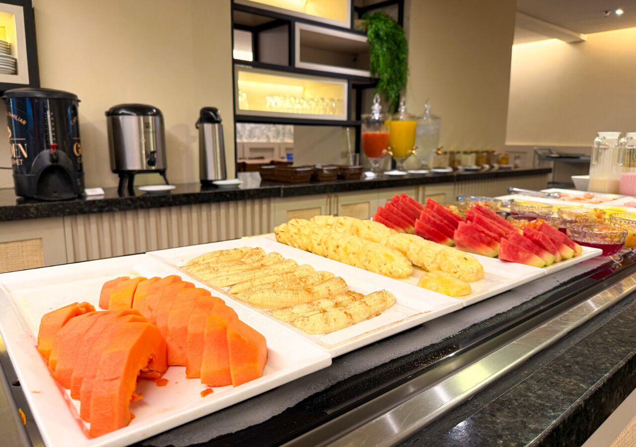 Buffet com diversos alimentos, incluindo frutas e legumes.