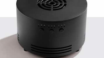 Um alto-falante cilíndrico preto, com botões de controle e fendas de ventilação.