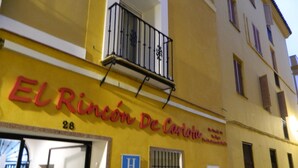Um edifício amarelo com uma placa que diz "EL Rincon De Carlota" e uma placa azul indicando um hospital nas proximidades.