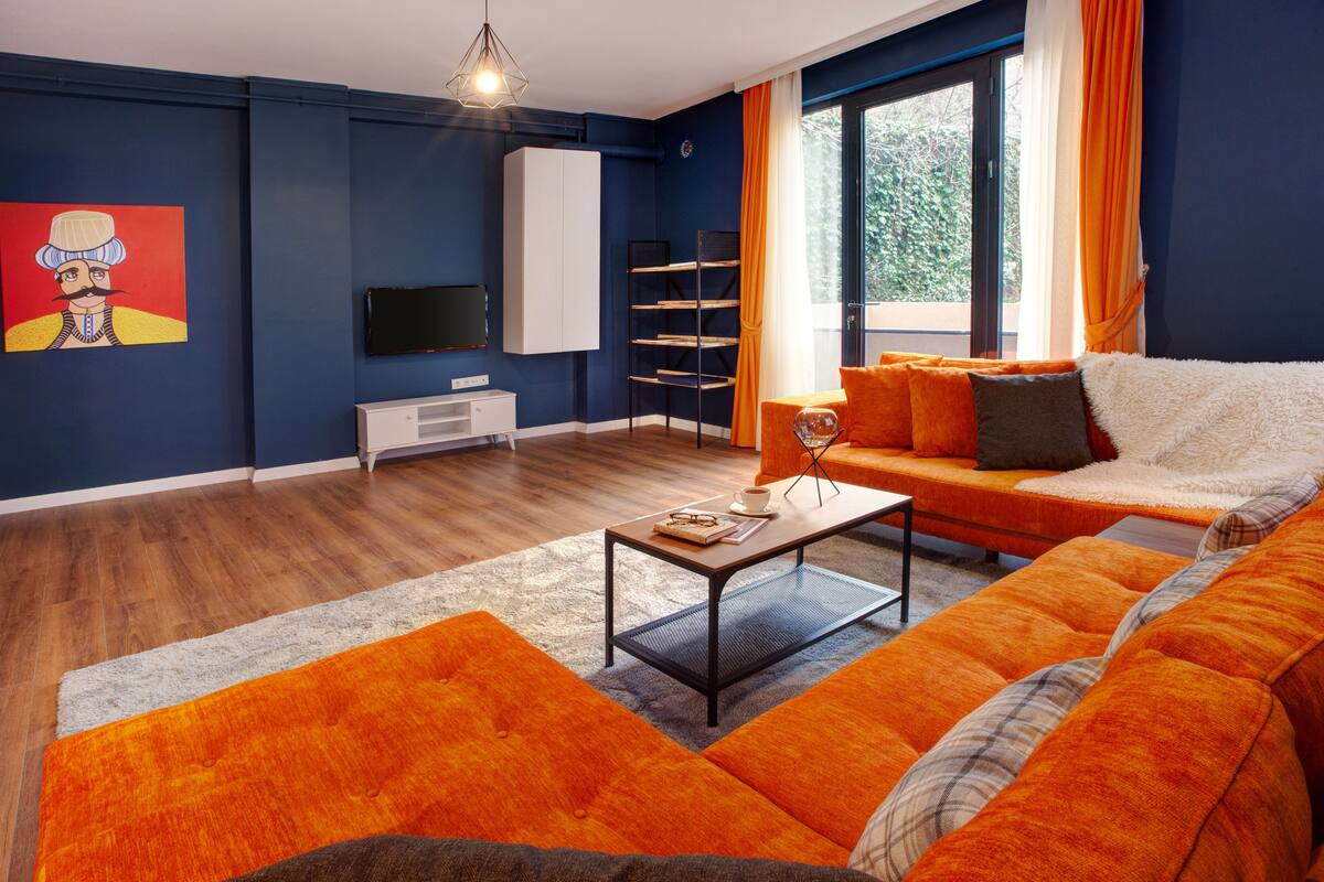 Uma sala de estar moderna com um sofá, mesa de centro e televisão.