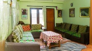Uma sala de estar com sofá, mesinha e tapete estampado.