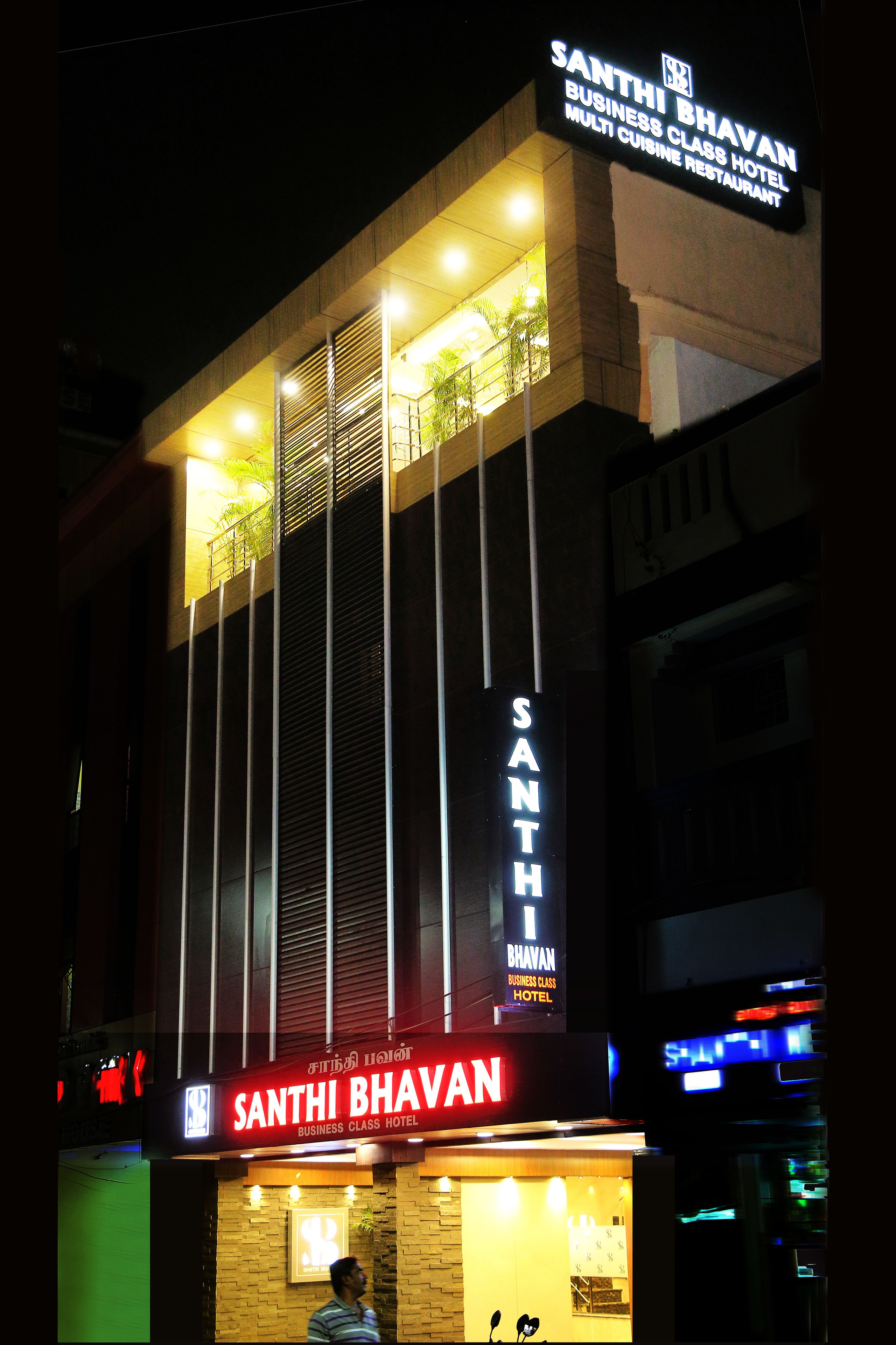 Um edifício com uma placa que diz "Santhi Bhavan Business Class Hotel".