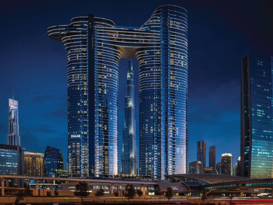 Um edifício moderno com muitos andares, design curvo característico e átrio central.