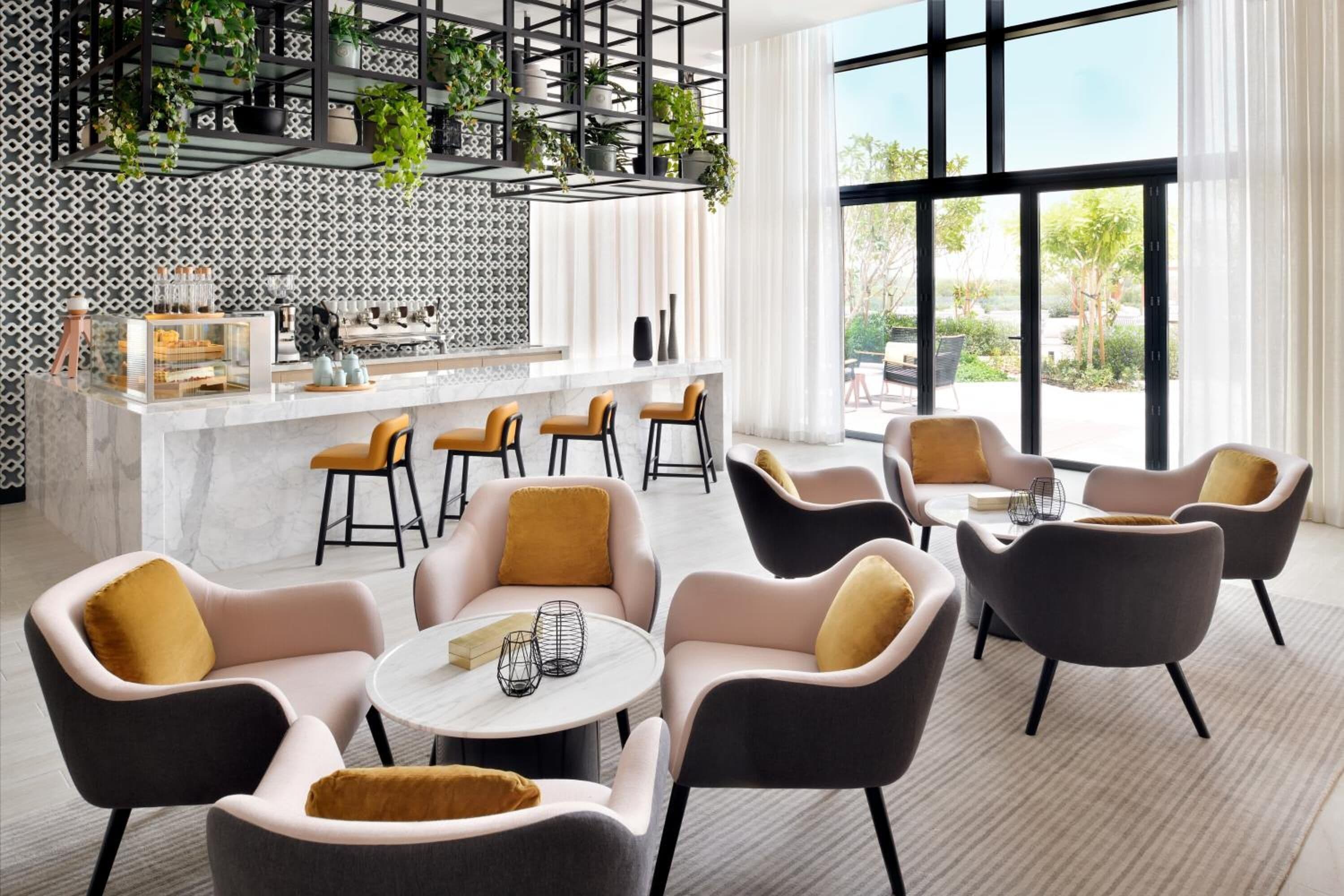 Um interior moderno com área de bar, assentos e grandes janelas.