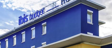 Um hotel com fachada azul e uma placa que diz 'é hotel econômico'.