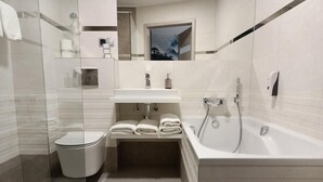 Uma casa de banho moderna com sanita, lavatório e banheira.