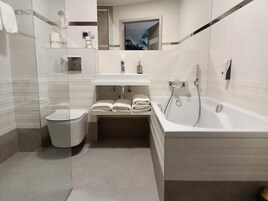 Uma casa de banho moderna com sanita, lavatório e banheira.