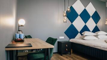 Quarto moderno com cama, mesa de cabeceira, abajur e parede com padrão geométrico.