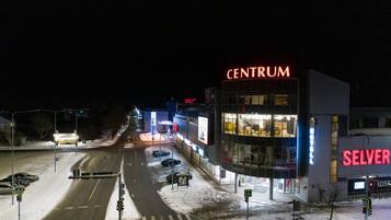 Um edifício com um destaque para a placa 'CENTRUM' e uma placa 'SELVER', indicando uma área comercial com estacionamento acessível.
