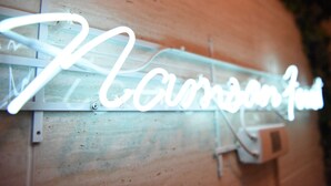 Um letreiro de neon com o texto 'Nashville Fun' em uma parede de madeira.