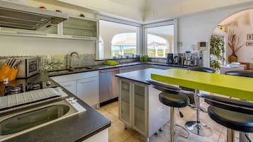 Uma placa de cozinha, uma máquina de lavar louça, utensílios de cozinha